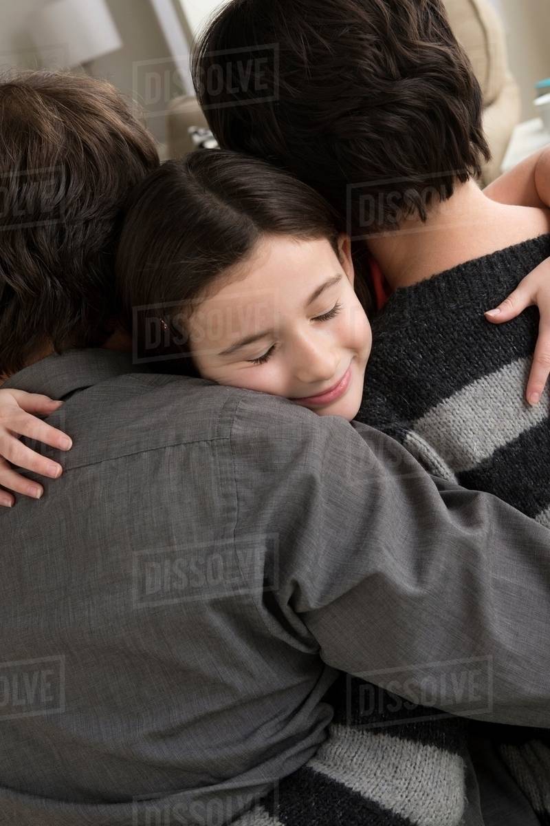Parents hugging daughter - Royalty-free Stock Photo | Dissolve