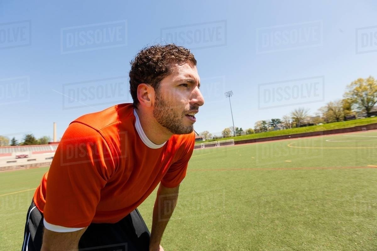 Soccer player taking a break on pitch - Stock Photo - Dissolve