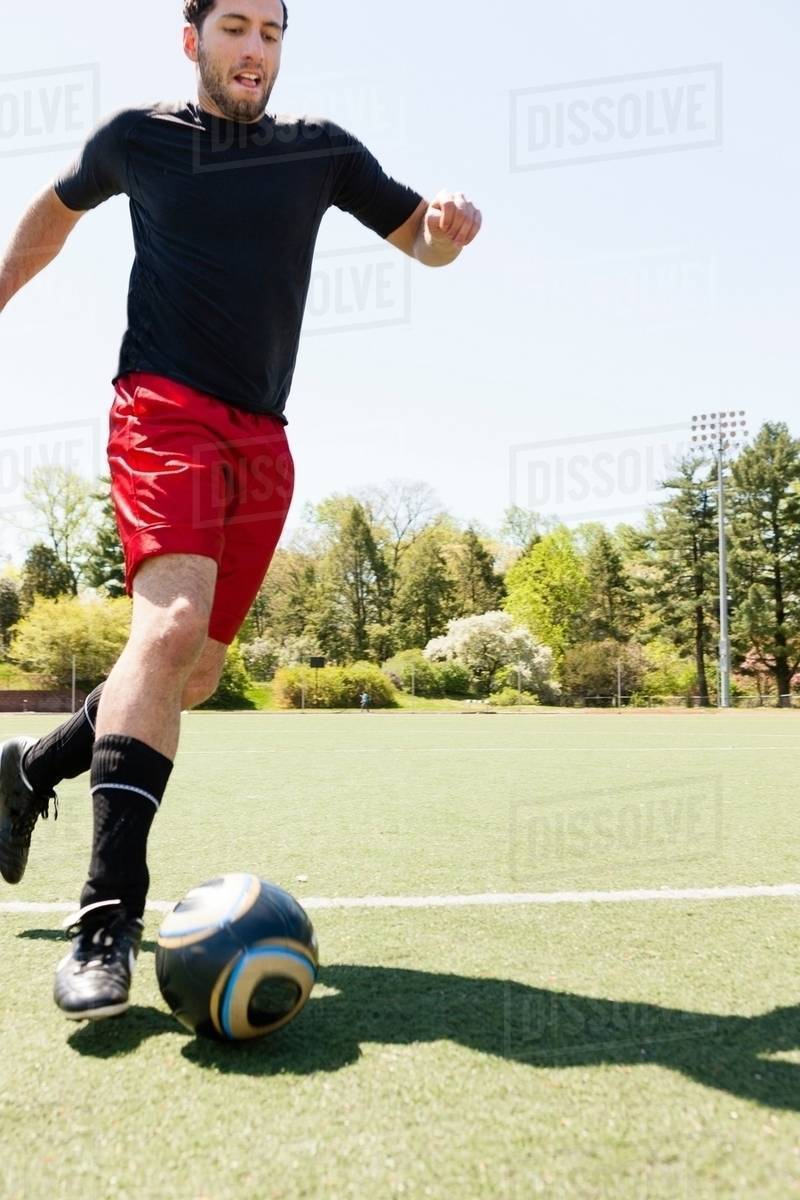Soccer player running and dribbling ball - Royalty-free Stock Photo ...