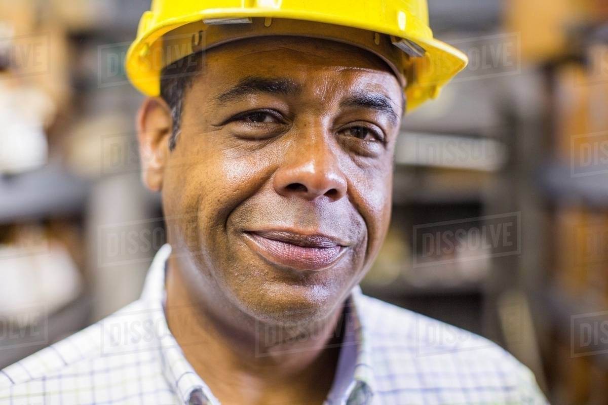 Close up portrait of man in stockroom wearing hard hat - Stock Photo ...