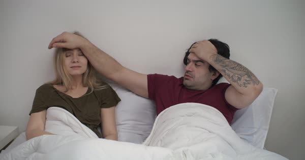 Frustrated sick couple lying in bed at home - Image - 4K Royalty-free ...