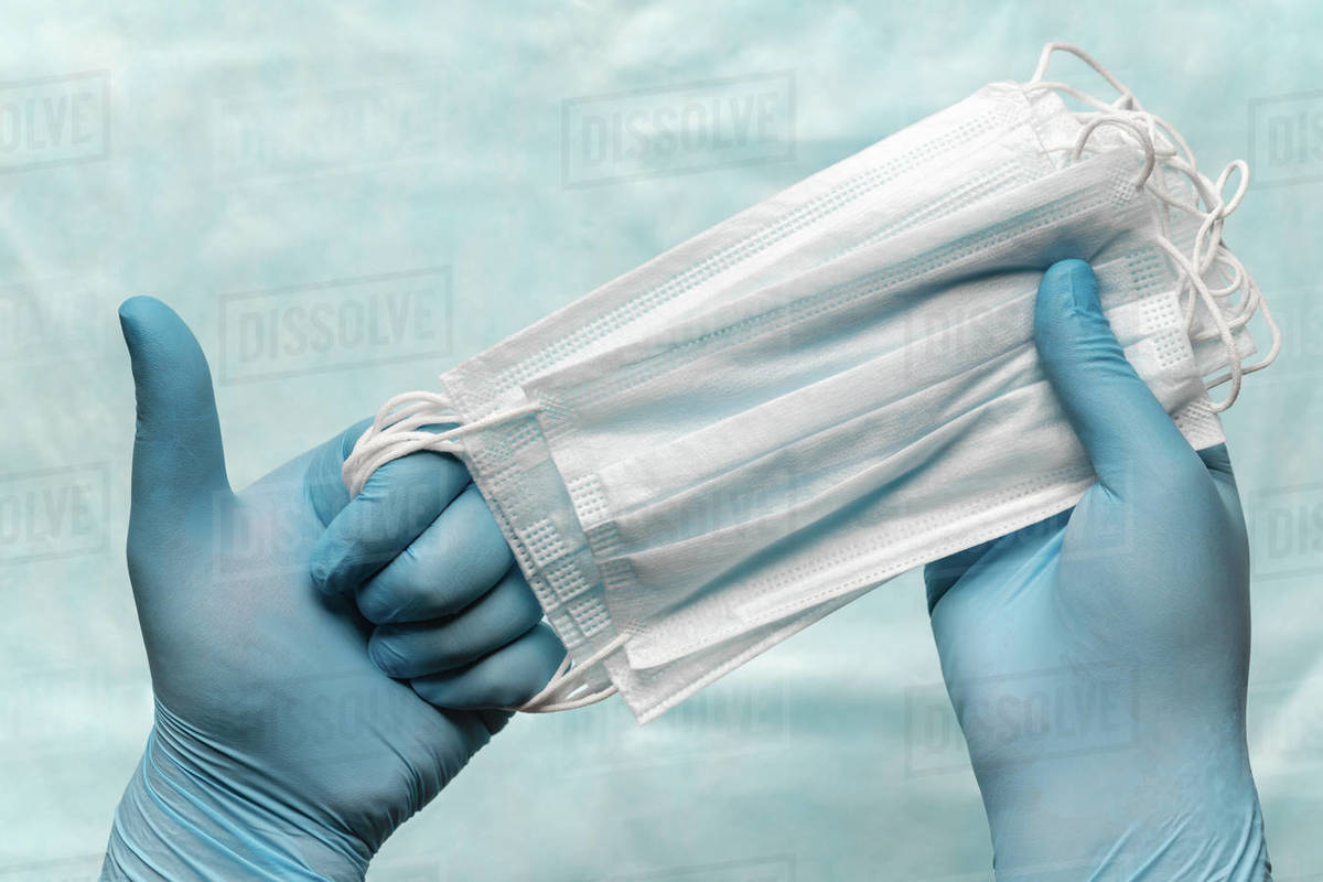 Doctor holding lot medical face mask in hands in blue medical gloves ...