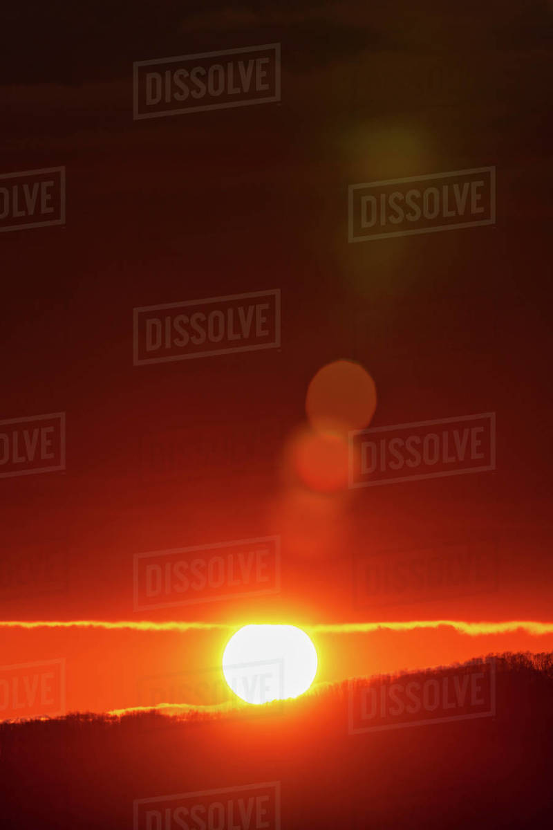 Rising of the sun in mountains, red-orange sun disk rises from tops of ...