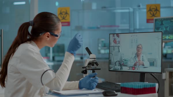Scientist talking to expert on video call conference in laboratory ...