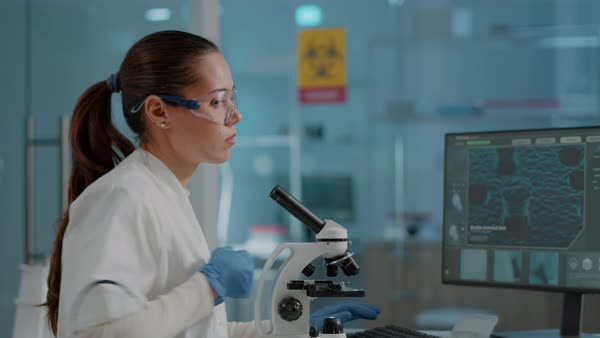 Science engineer using microscope to analyze dna sample in laboratory ...