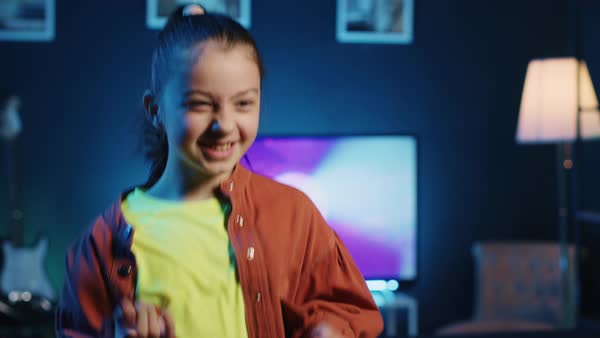 Cute smiling kid filming dance tutorial for other children watching her ...