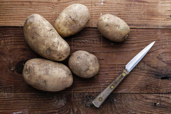 An overview photograph of whole potatoes on a pearing knife. - Royalty ...