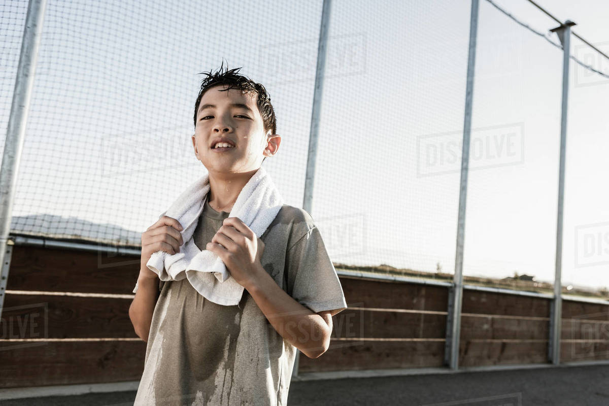 A confident boy with a towel around his neck after a hard practice ...