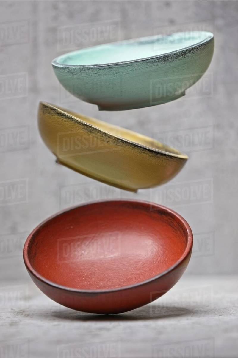 A conceptual studio photo of three bowls being dropped. - Royalty-free ...