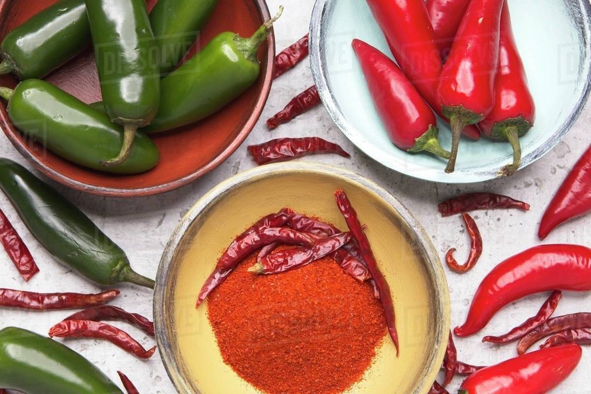 Various spicy peppers and dried peppers on the bowls and on the ...