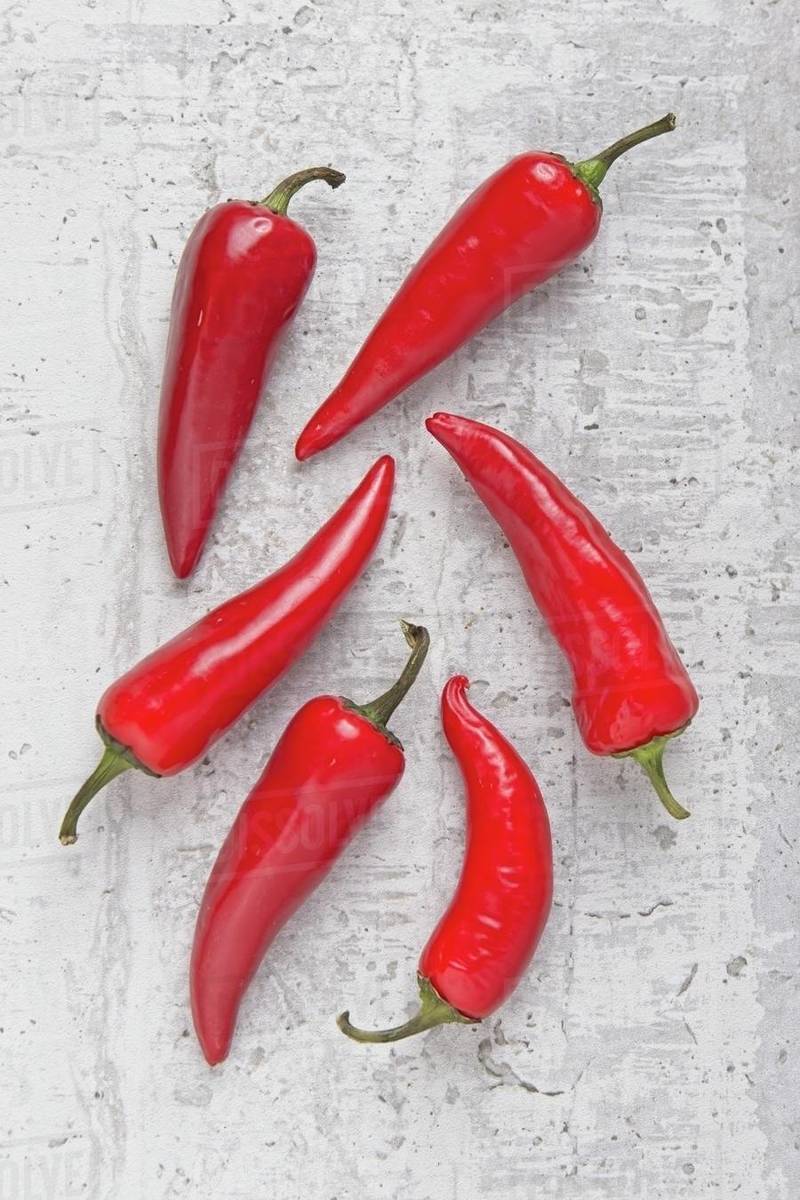 An overview photo of spicy whole red peppers layed out in a display on ...