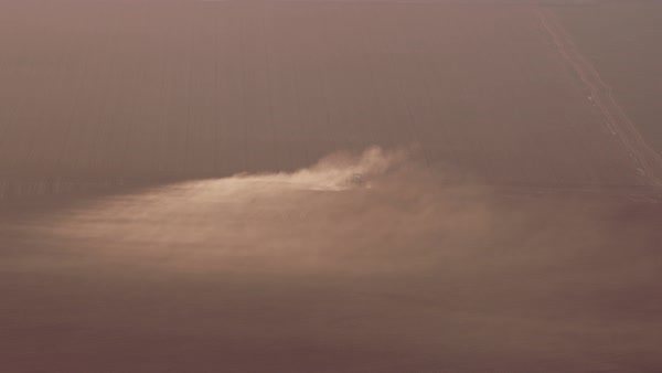 Tractor plowing dusty field aerial view - Stock Video Footage - Dissolve