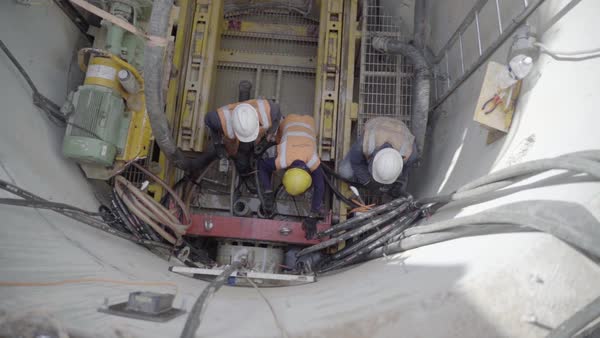Men at Heavy Industry engineers site working Inside concrete pipe tube ...