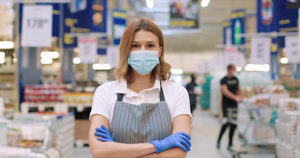 Close up portrait of Caucasian pretty female food store worker in mask ...
