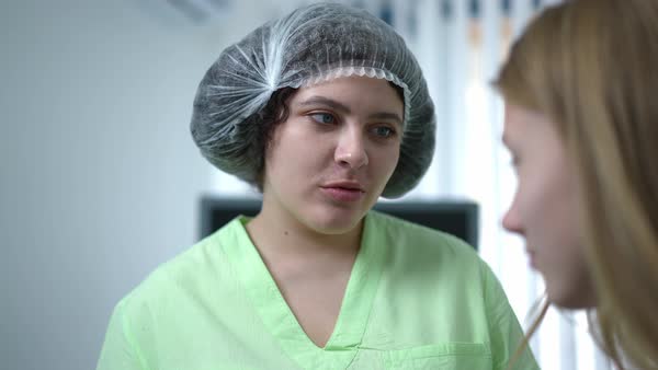 Expert Caucasian plus-size doctor talking with patient smiling ...
