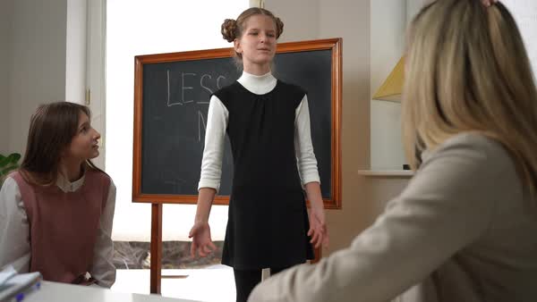 Positive intelligent teen girl talking with teacher and classmate ...