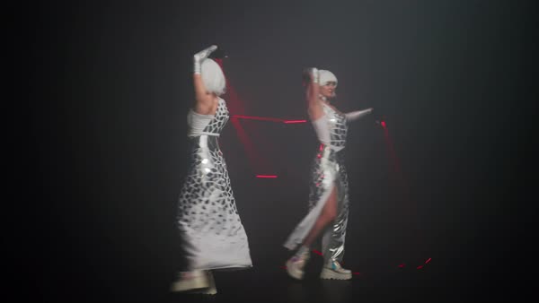 Two slim beautiful women in futuristic costumes with laser beams ...