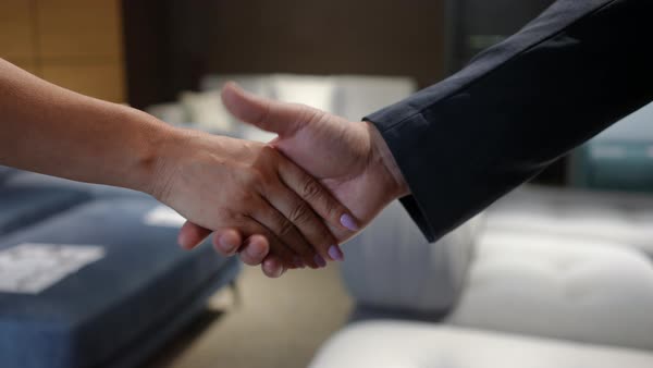 Close-up handshake of male female hands in furniture salon in slow ...