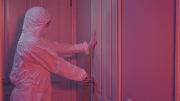 Young female laboratory worker coming into room with red lighting ...