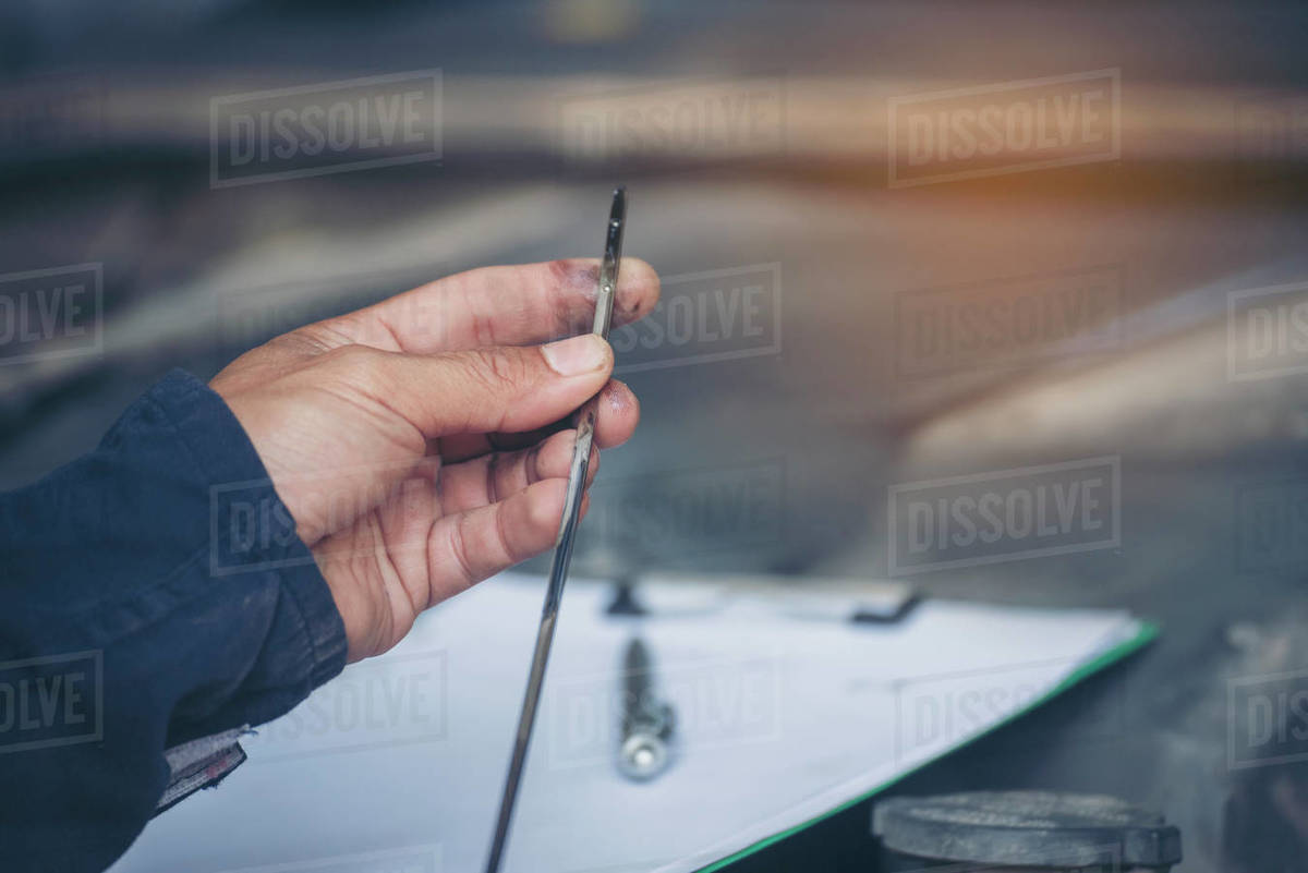 Car Mechanic man hand checking dipstick engine oil car mechanical on ...