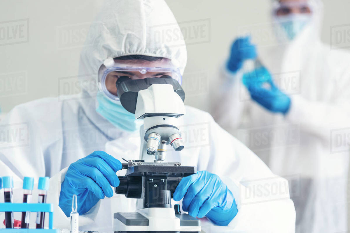 Male Scientist look into Microscope researching in science laboratory ...