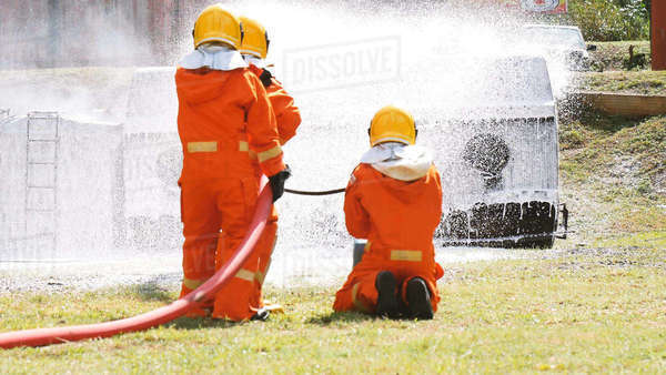 Firefighter fighting with flame using fire hose chemical water foam ...