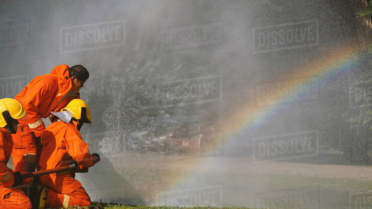 Firefighter fighting with flame using fire hose chemical water foam ...