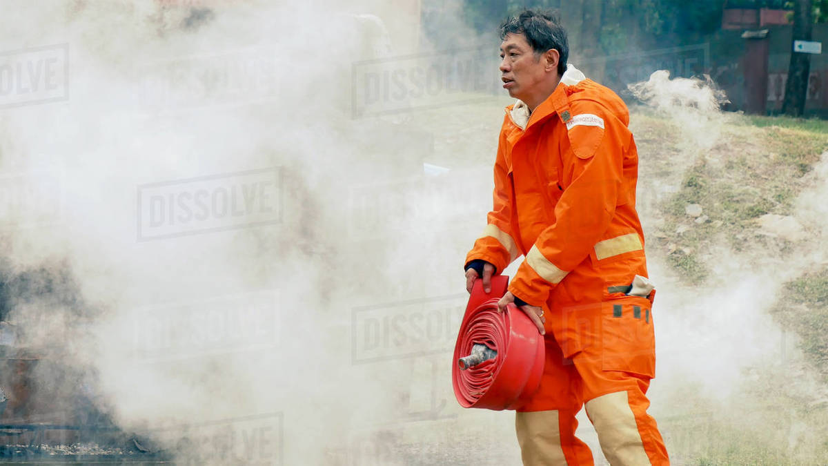Firefighter fighting with flame using fire hose chemical water foam ...