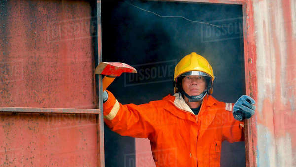 Firefighter fighting with flame using fire hose chemical water foam ...