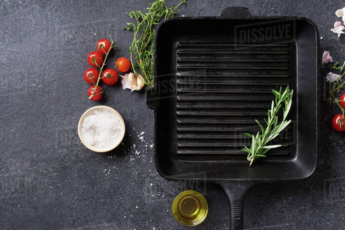Flat lay top view black cast iron skillet for barbecue. Frying pan with ...