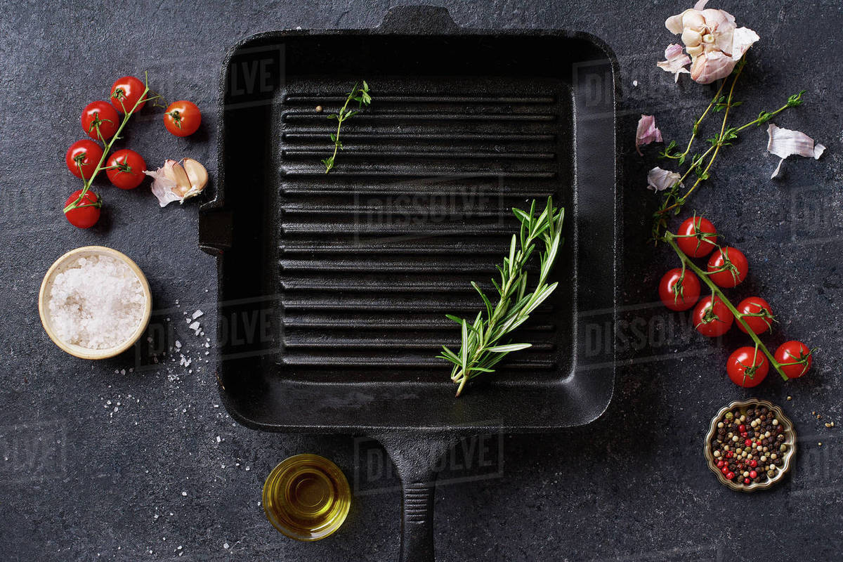 Flat lay top view black cast iron skillet for barbecue. Frying pan with ...