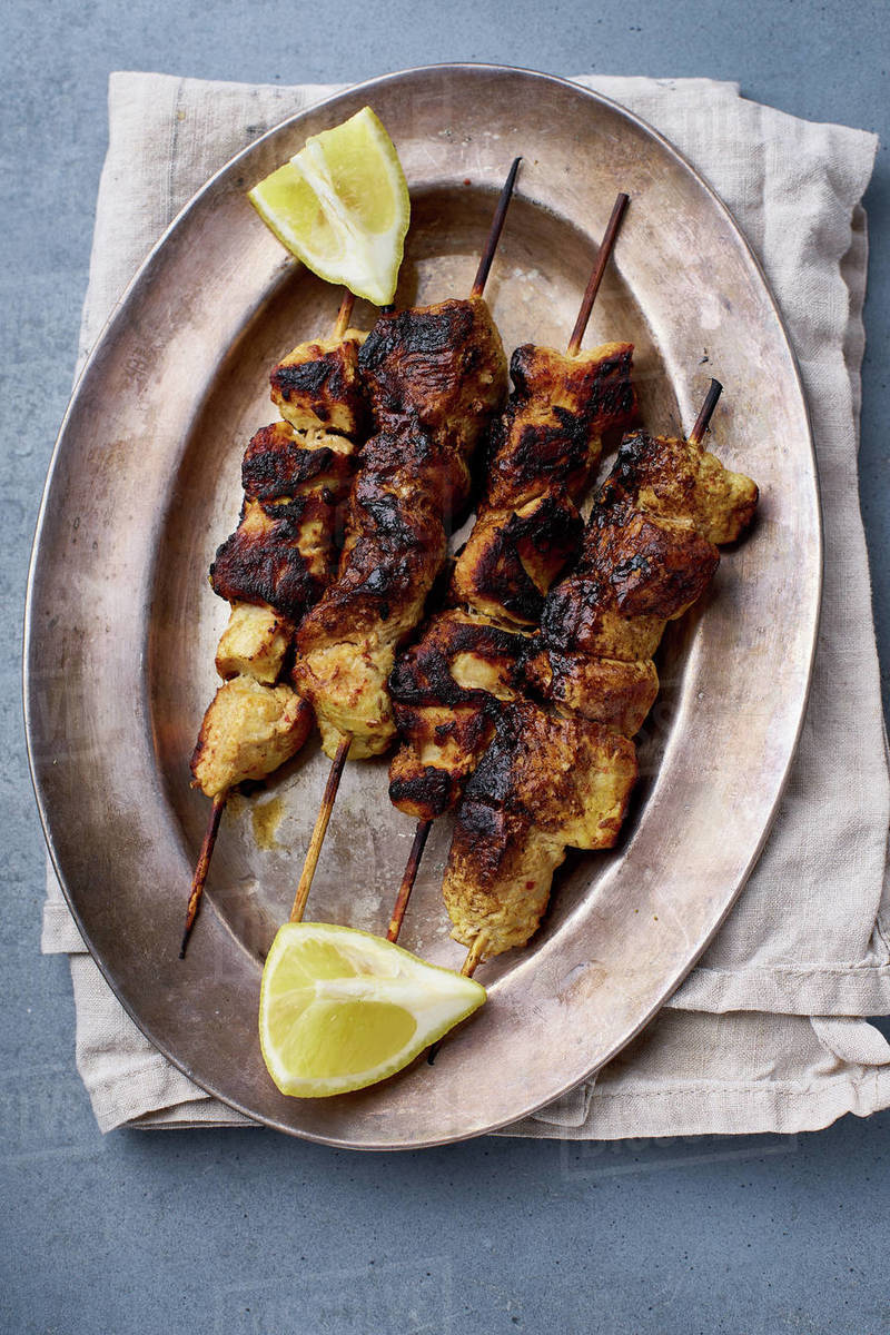 Close-up image of chicken tikka kebab with marinated onion, fresh salad ...