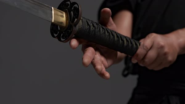 Japanese man, samurai, holds in his hand his sword, a katana in a ...