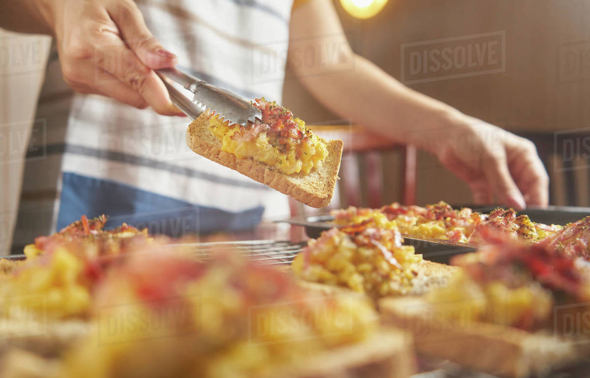 The chef picks the bread with eggs and bacon into it cooling rack ...