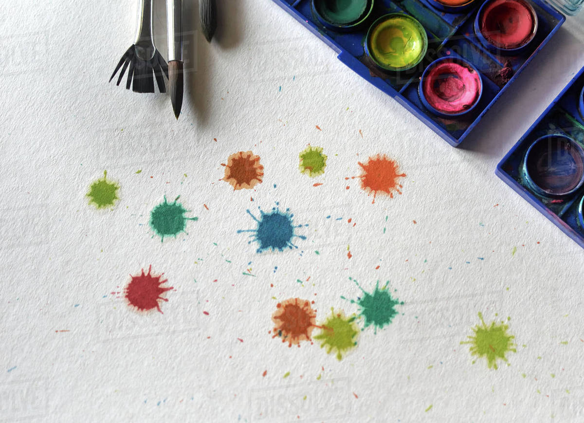 Paintbrushes with the color palettes and the color stains on the rough ...