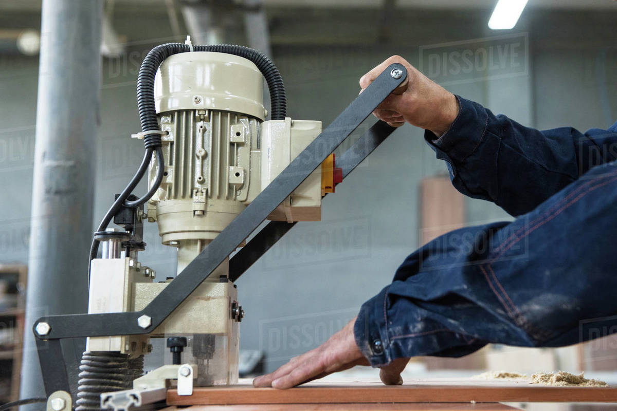 Furniture production concept: man working at machine and making ...