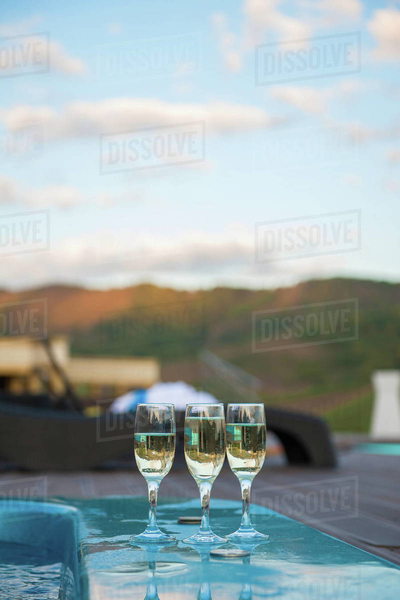 Three glass of cool champagne wine outdoor in a restaurant pool ...