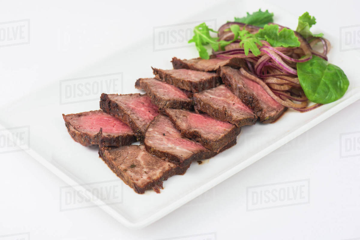 Plate with meat cutting and fresh greens on white plate - Royalty-free ...
