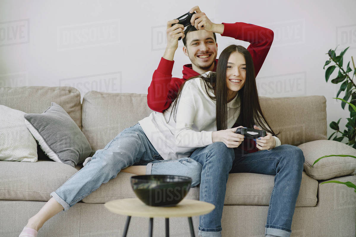Couple with joysticks. People at home. Pair playing a video games ...