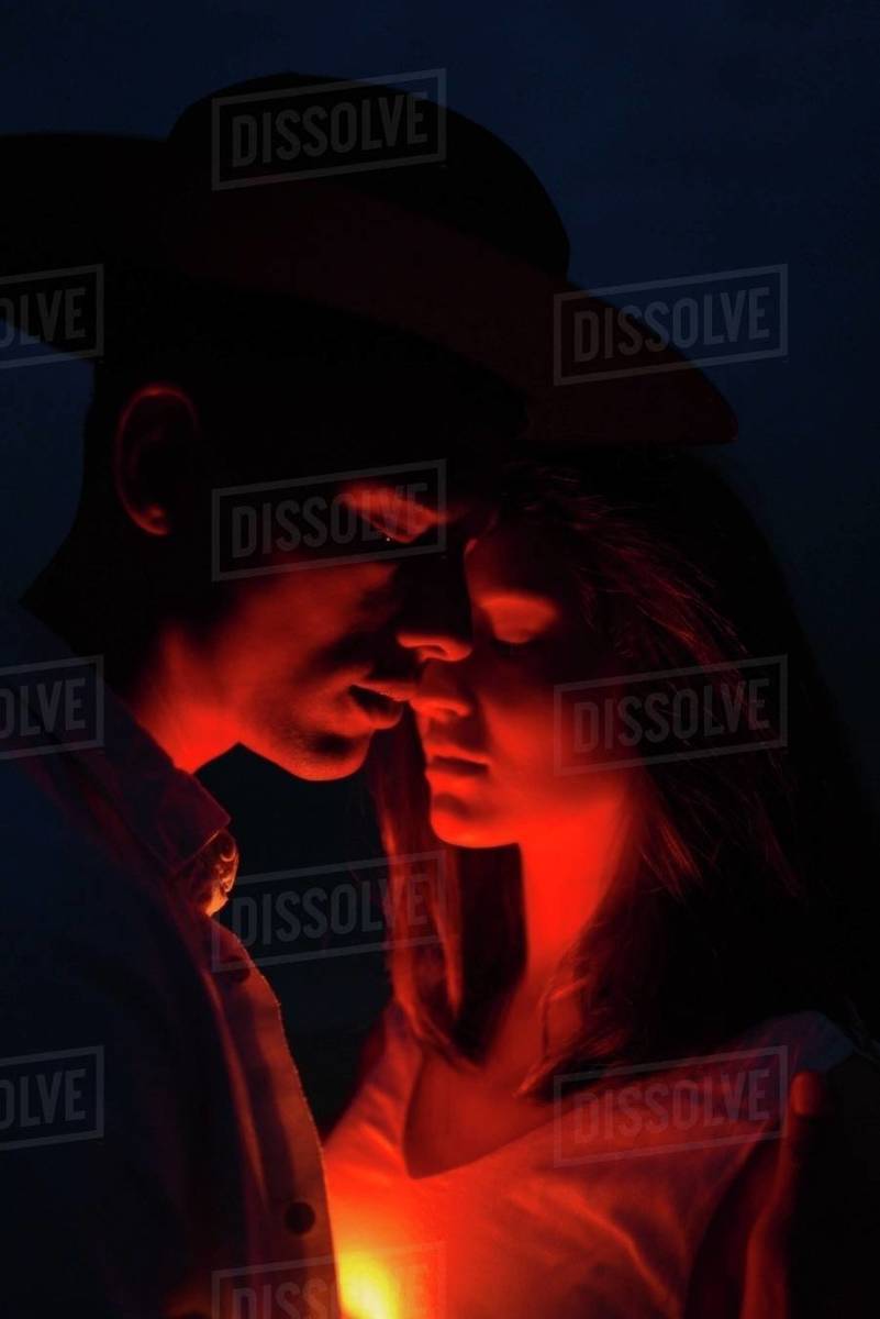 Couple hugging in the dark with neon light - Stock Photo - Dissolve