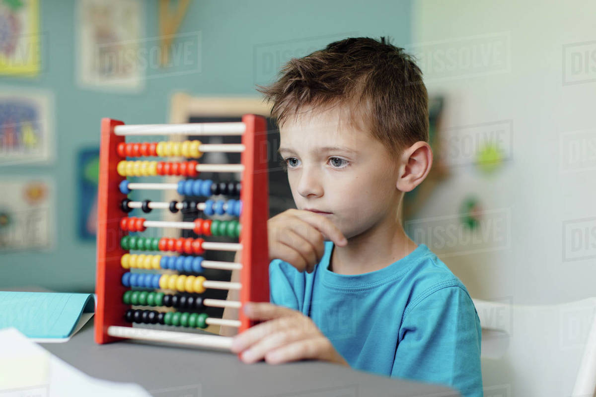 Thinking schoolboy learning maths with an abacus - Royalty-free Stock ...