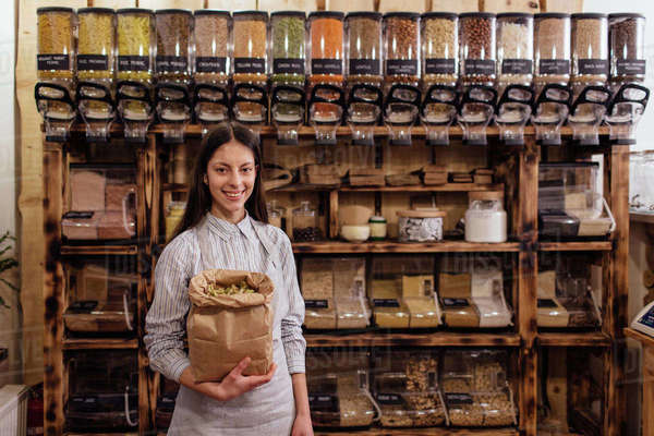 Portrait of smiling shopkeeper in package free grocery store. Cheerful ...