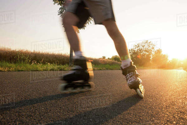 Young man enjoying roller skating on the bicycle path during lovely ...