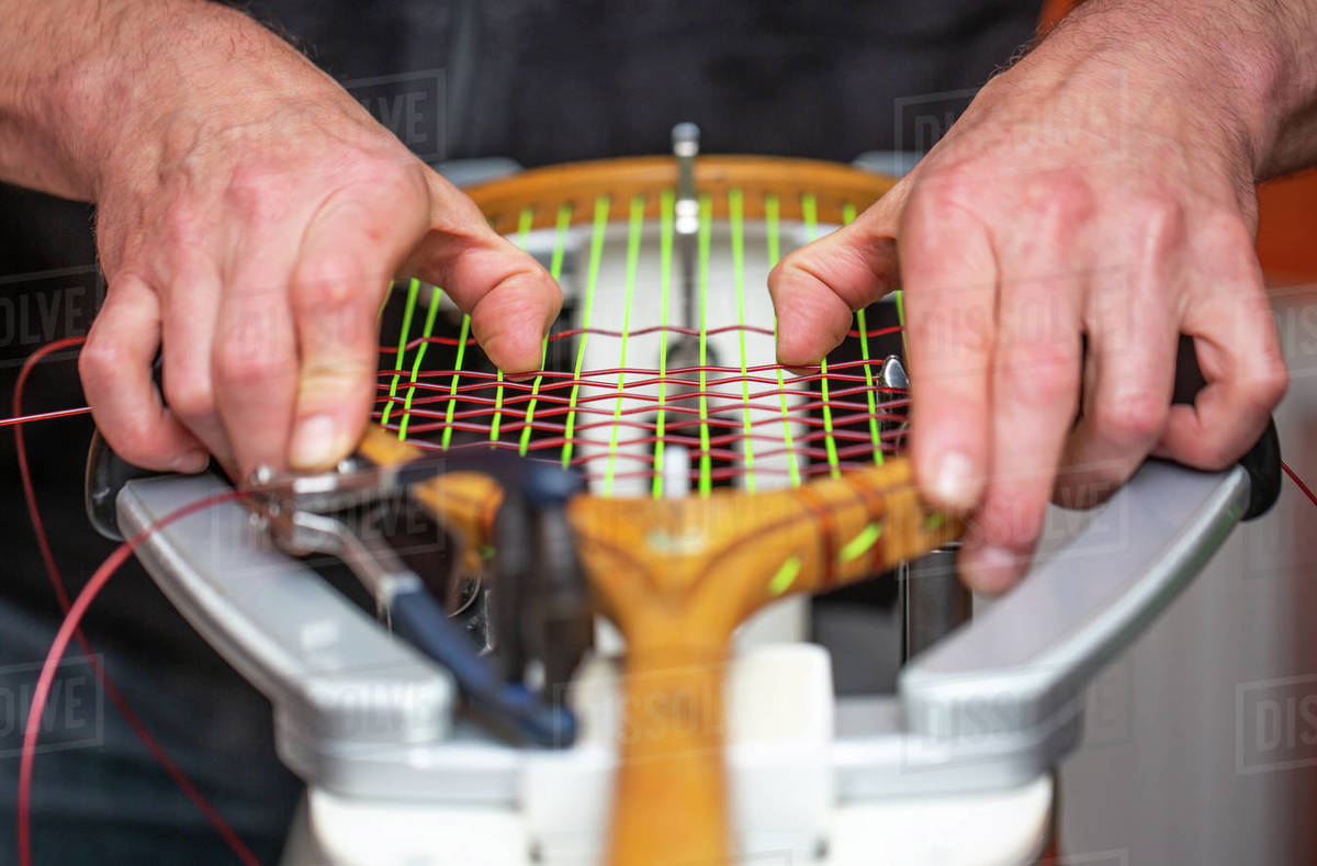 Process of stringing historic or retro tennis racket in a tennis shop ...