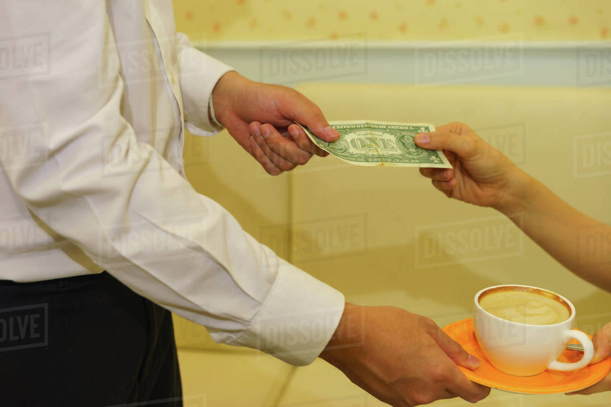 Woman hands one dollar banknote for tip to waiter after received latte ...