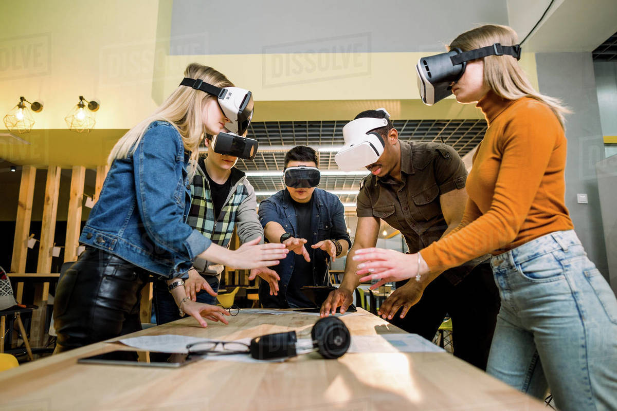 Business people using virtual reality goggles during meeting. Team of ...