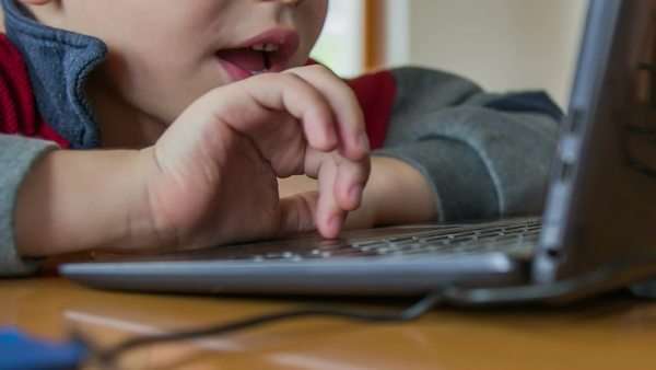 Sliding on touch pad with fingers close up. Child using laptop and ...