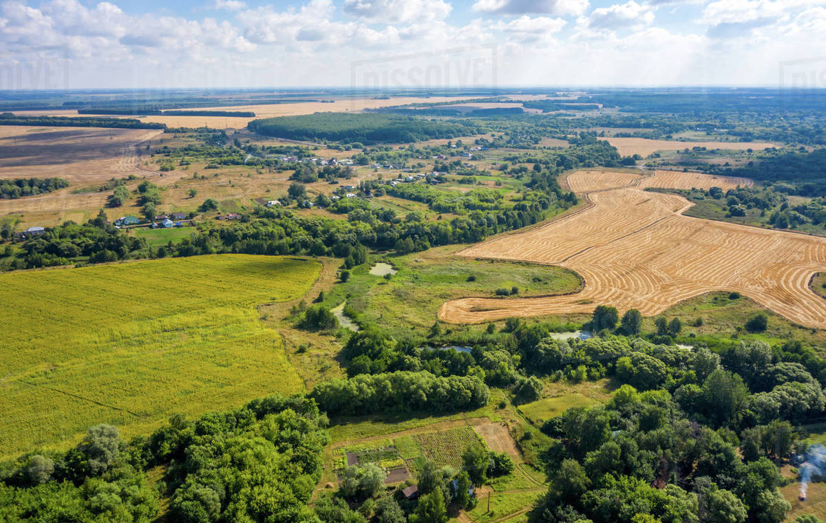 aerial photography of a winding river skirting a mown field and flowing ...