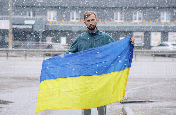 Young angry man holds ukrainian flag in his hands and protests against ...