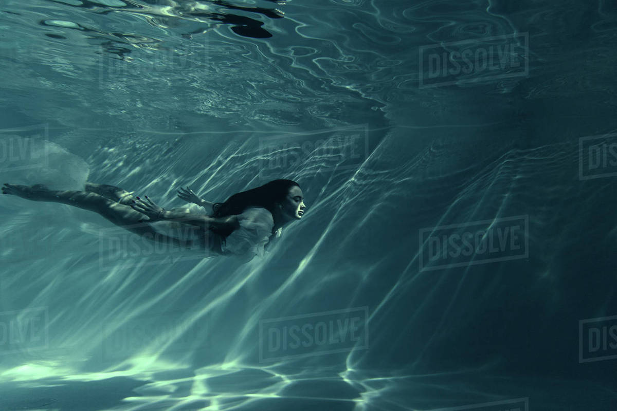 Underwater shoot of beautiful woman in white flying transparent dress ...